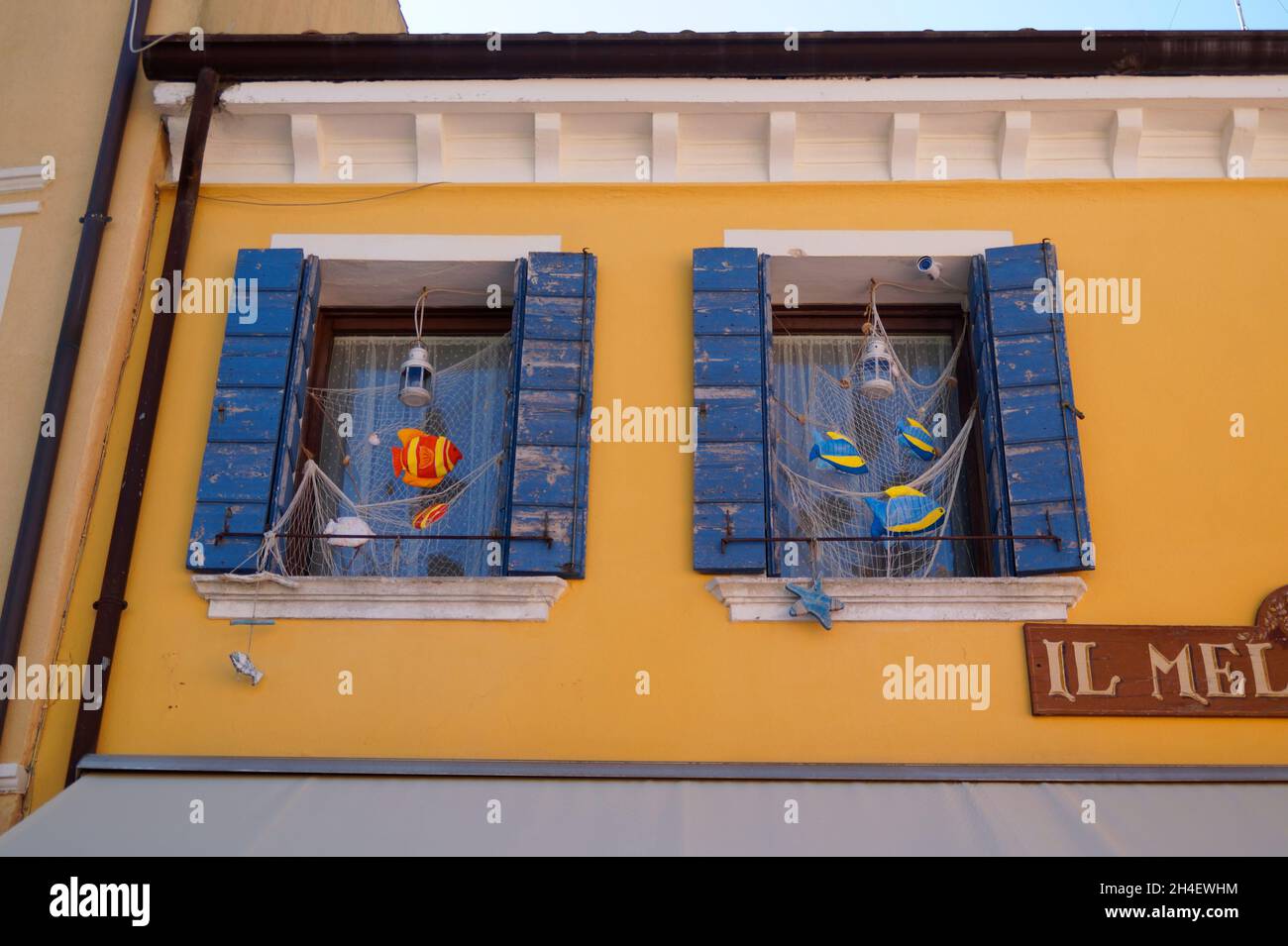 quaint windows with blue shutters in the mediterranean town of Caorle ...