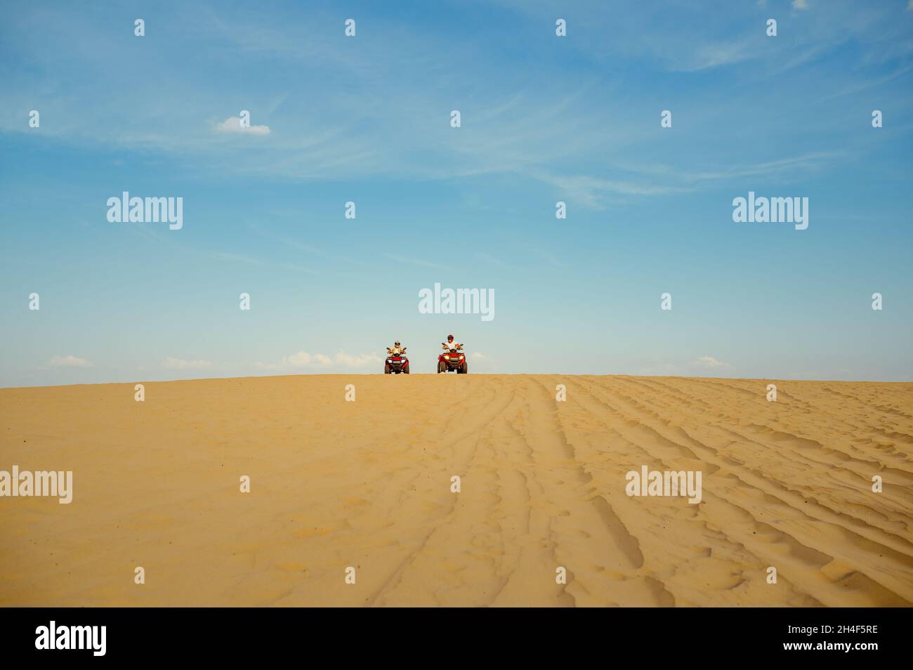 Two racers riding on atv in desert, afar view Stock Photo - Alamy