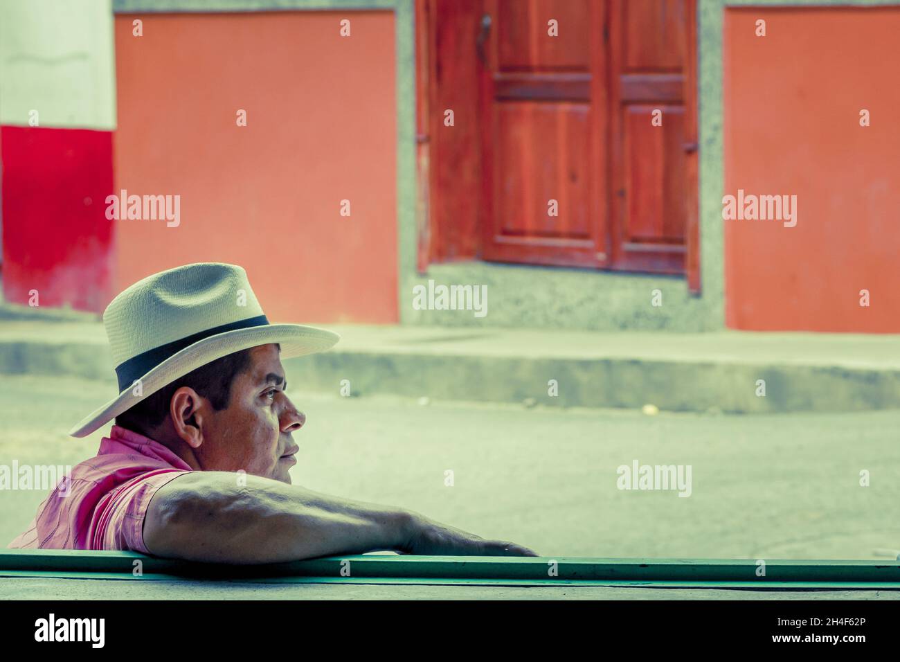 Man in hat sitting at a window arm resting on window sill Stock Photo ...