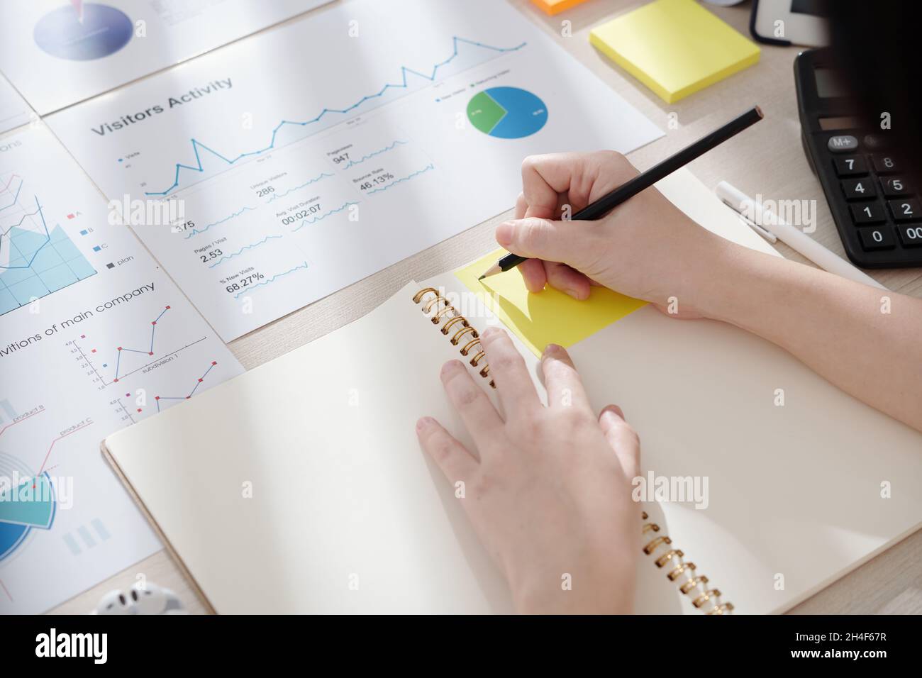 Creative business person writing ideas and things to remember on sticky ...