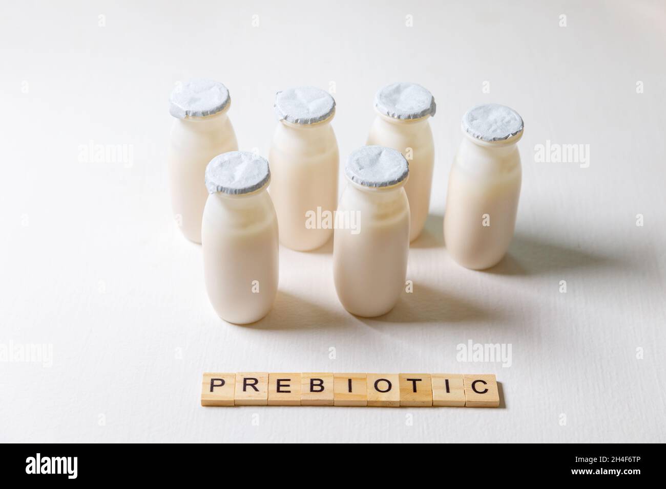 Small bottles with probiotics and prebiotics dairy drink on white ...