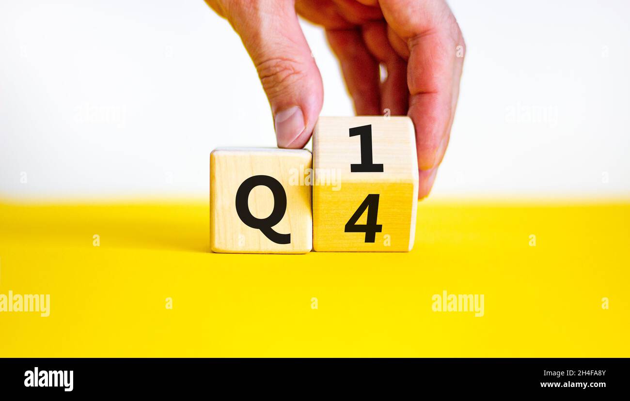 From 4th to 1st quarter symbol. Businessman turns a wooden cube and ...
