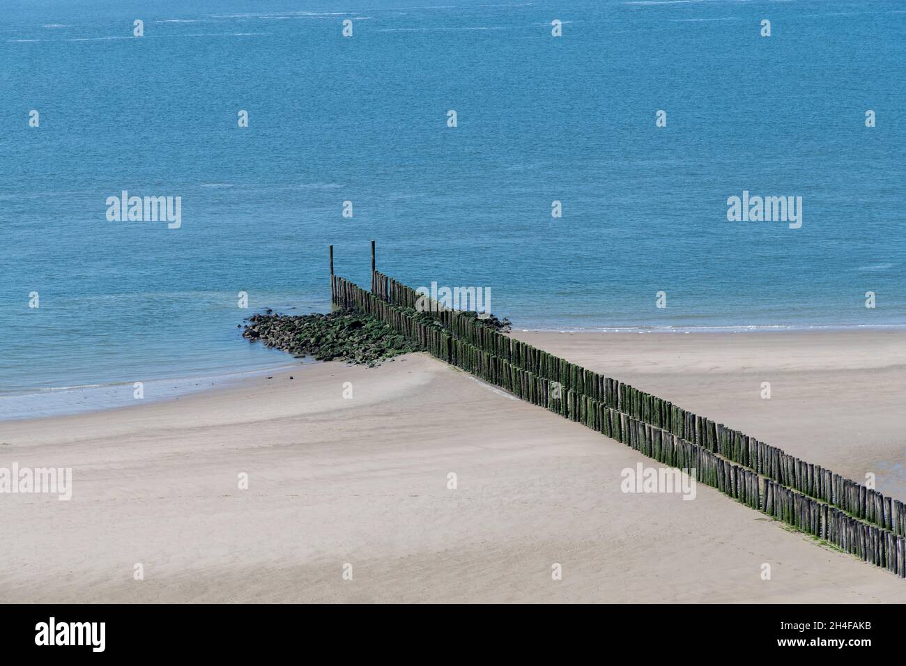 High angle view of two diagonal parallel rows of wooden breakwaters on ...