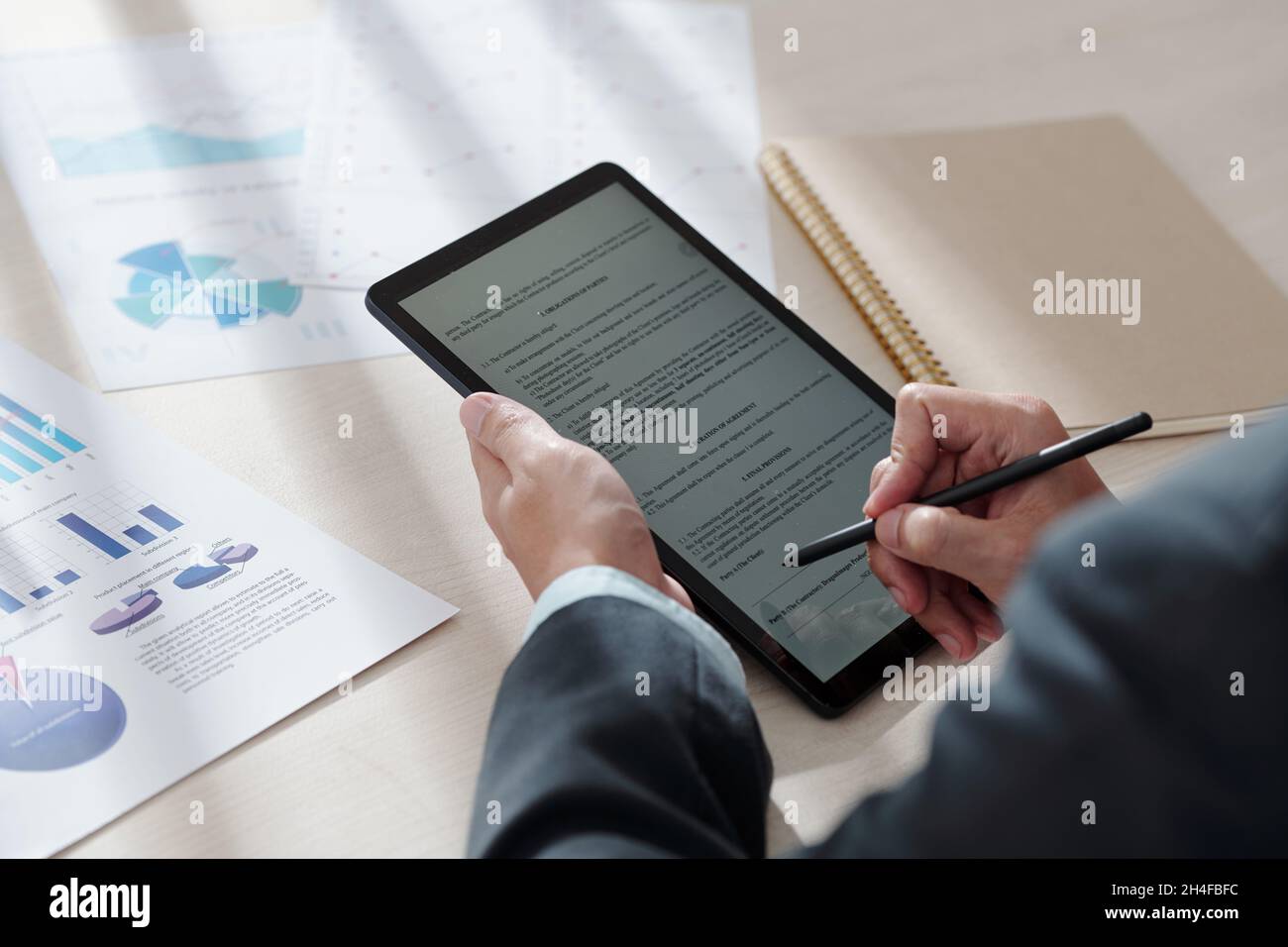 Hands of businessman with digital pen reading and signing document on ...