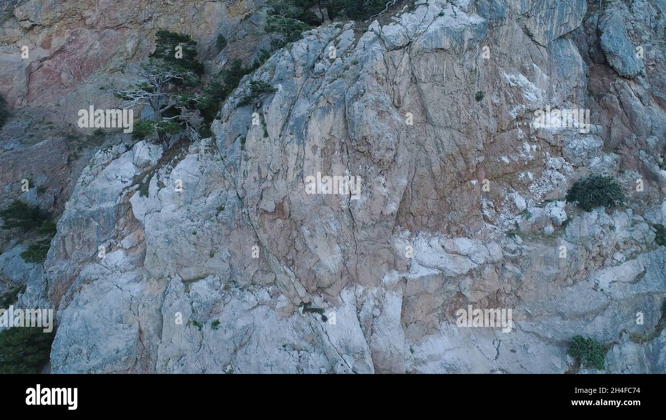 Steep cliff with ledges. Shot. Top view of rocky steep wall with sparse ...