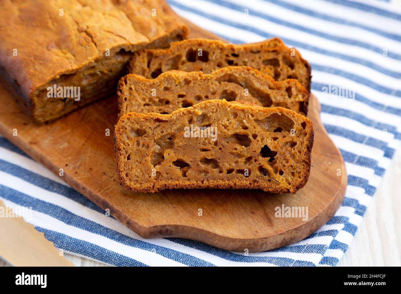 Homemade Pumpkin Loaf Bread on a rustic wooden board on a white wooden ...