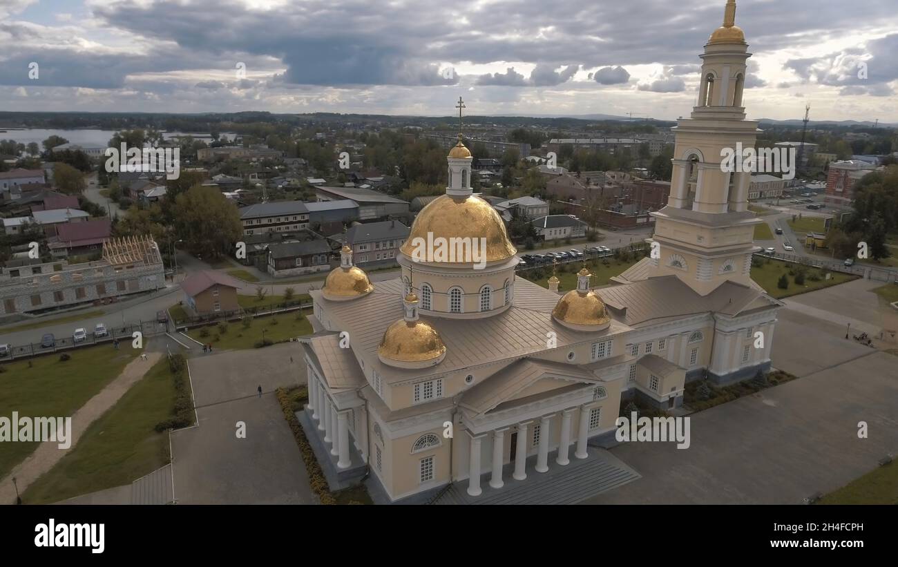 Aerial view of the beautiful white church with a tower and gold domes ...