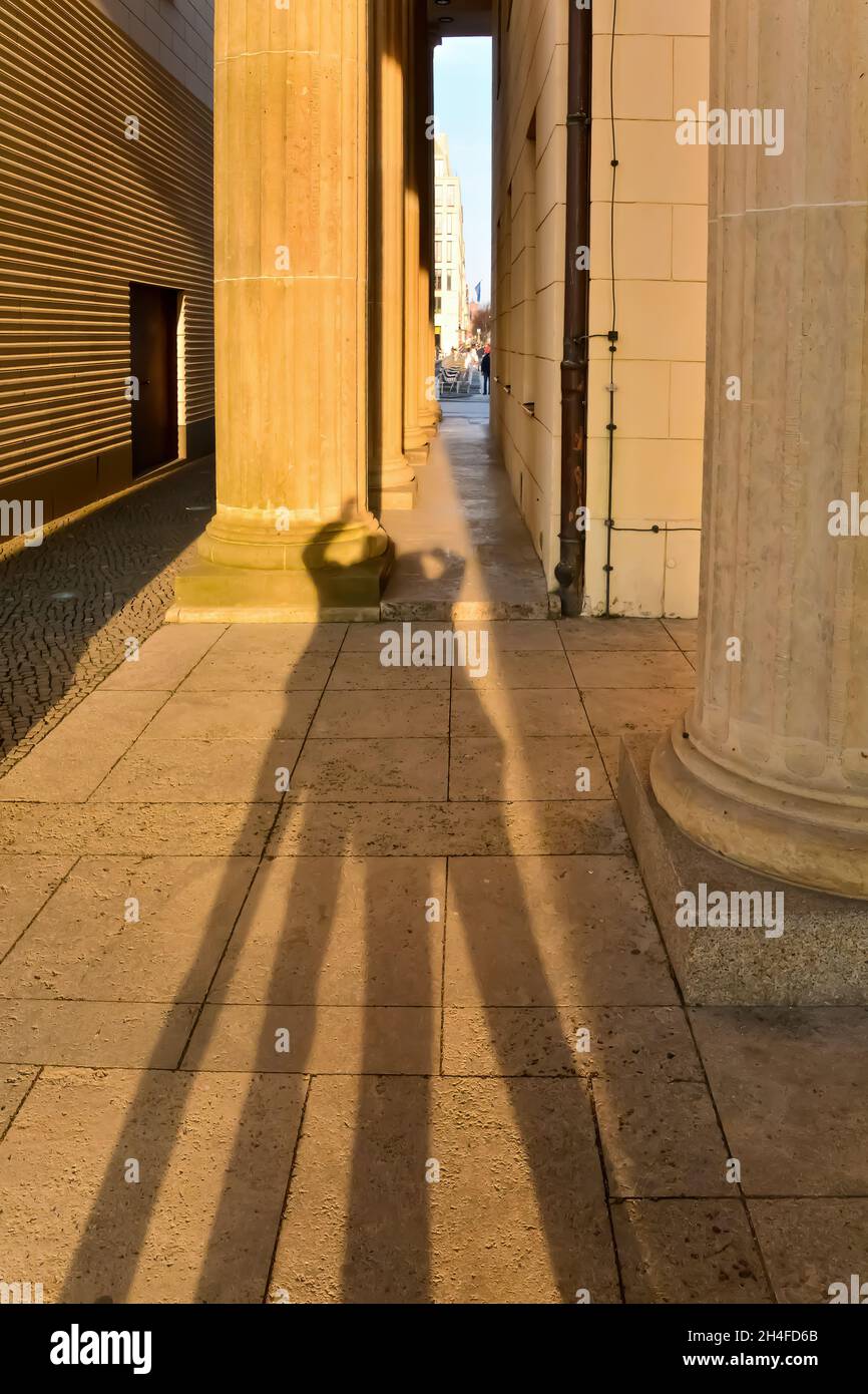 Shadow selfie of people arms raised between the columns of 18th-century ...