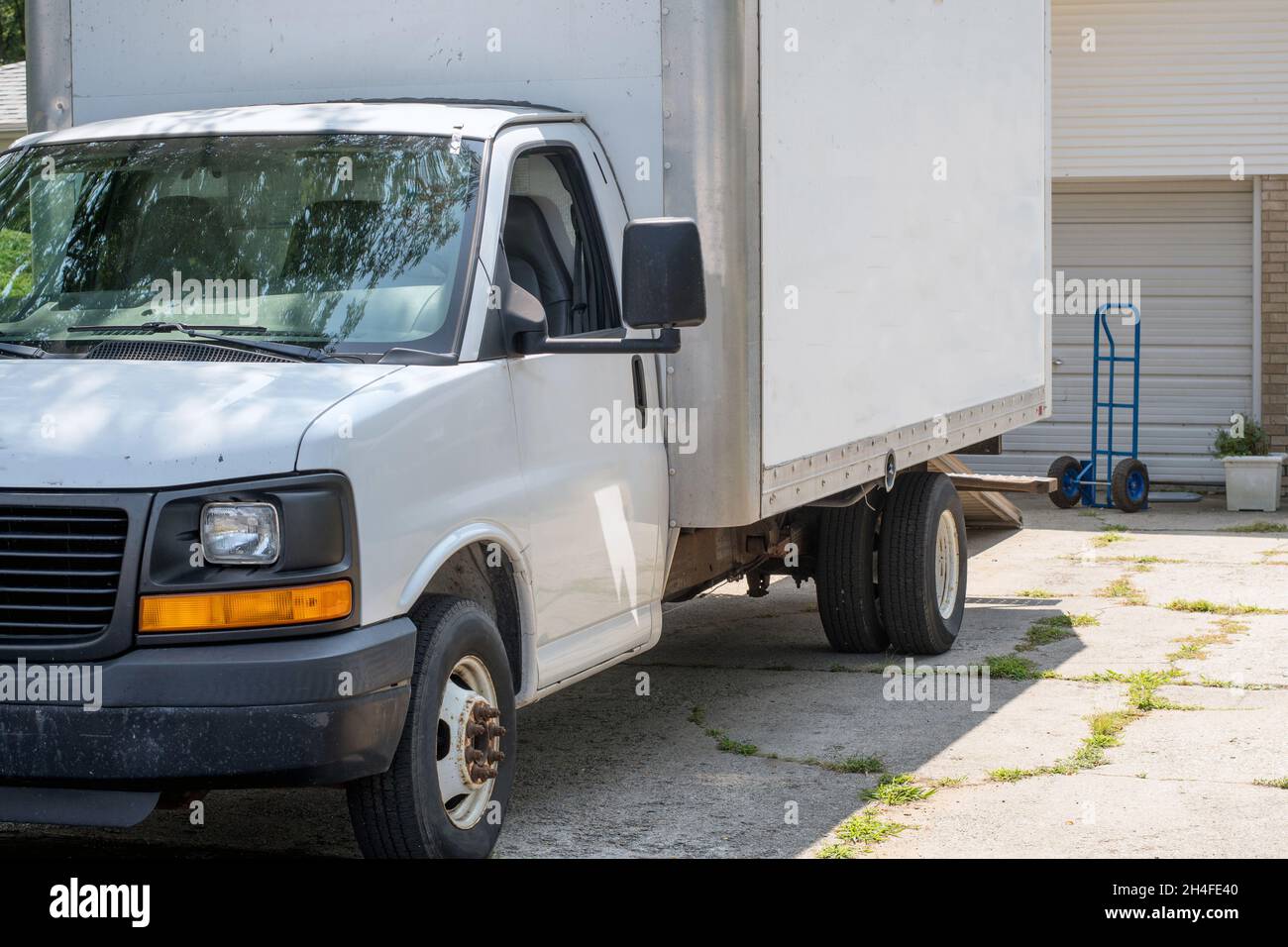 moving van waits in the driveway with a blue dolly ready to load up for ...