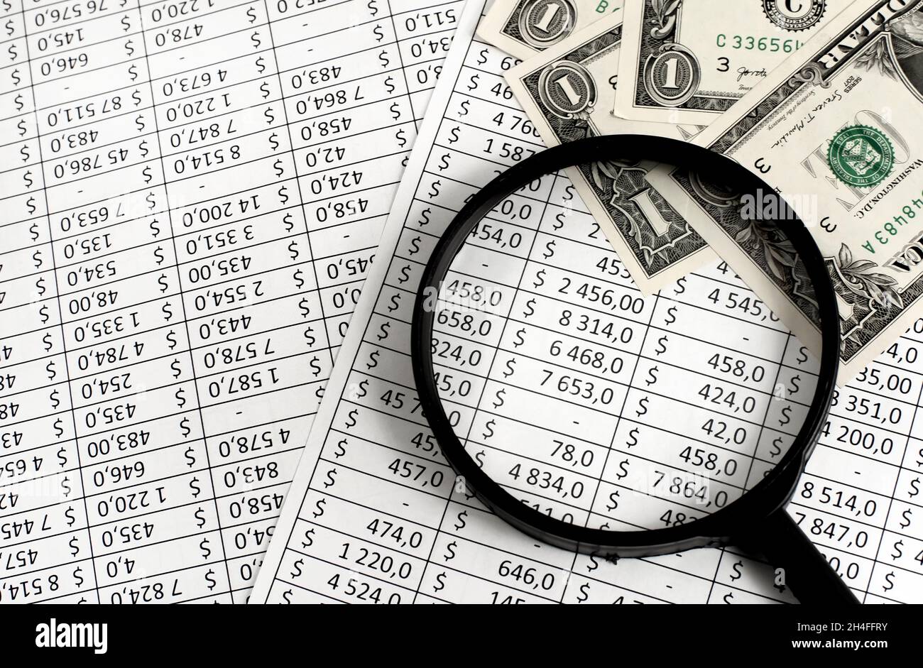 Dollars and money estimate through a magnifying glass close-up. Finance ...