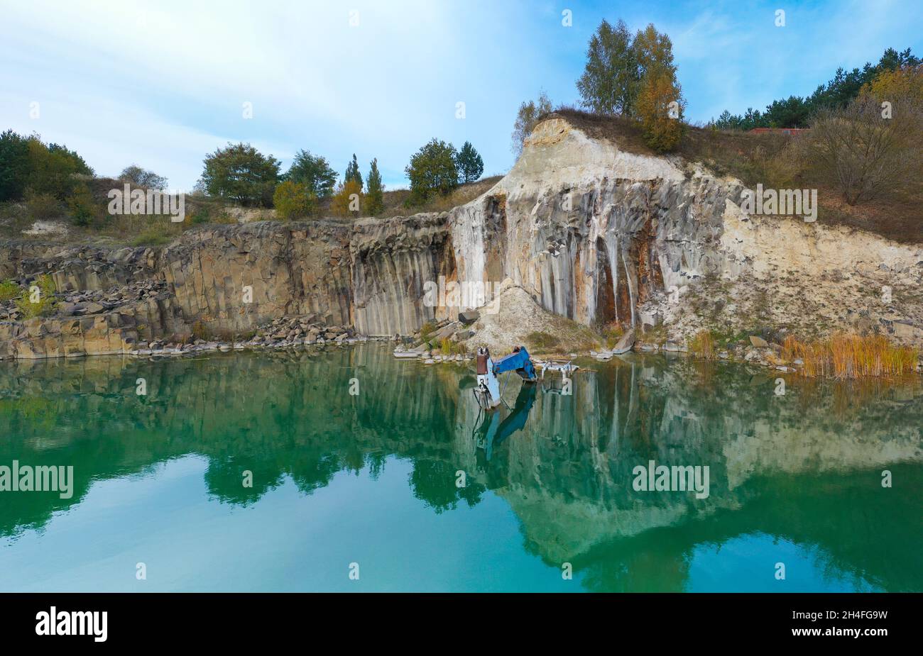 Flooded basalt quarry with sunken excavator.Drone view Stock Photo - Alamy