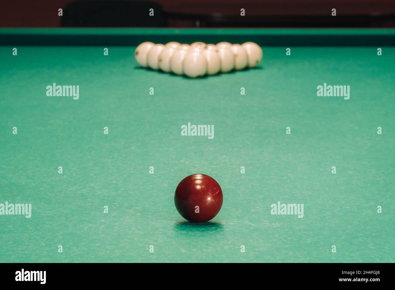 They play pool on a green table.The balls are placed in a triangle on ...