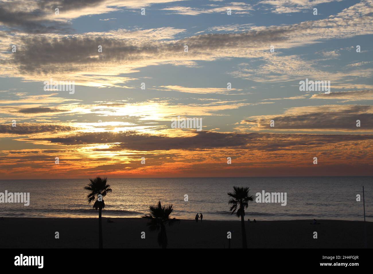 Romantischer Sonnenuntergang am Meer mit Sandstrand, mit zwei Palmen ...