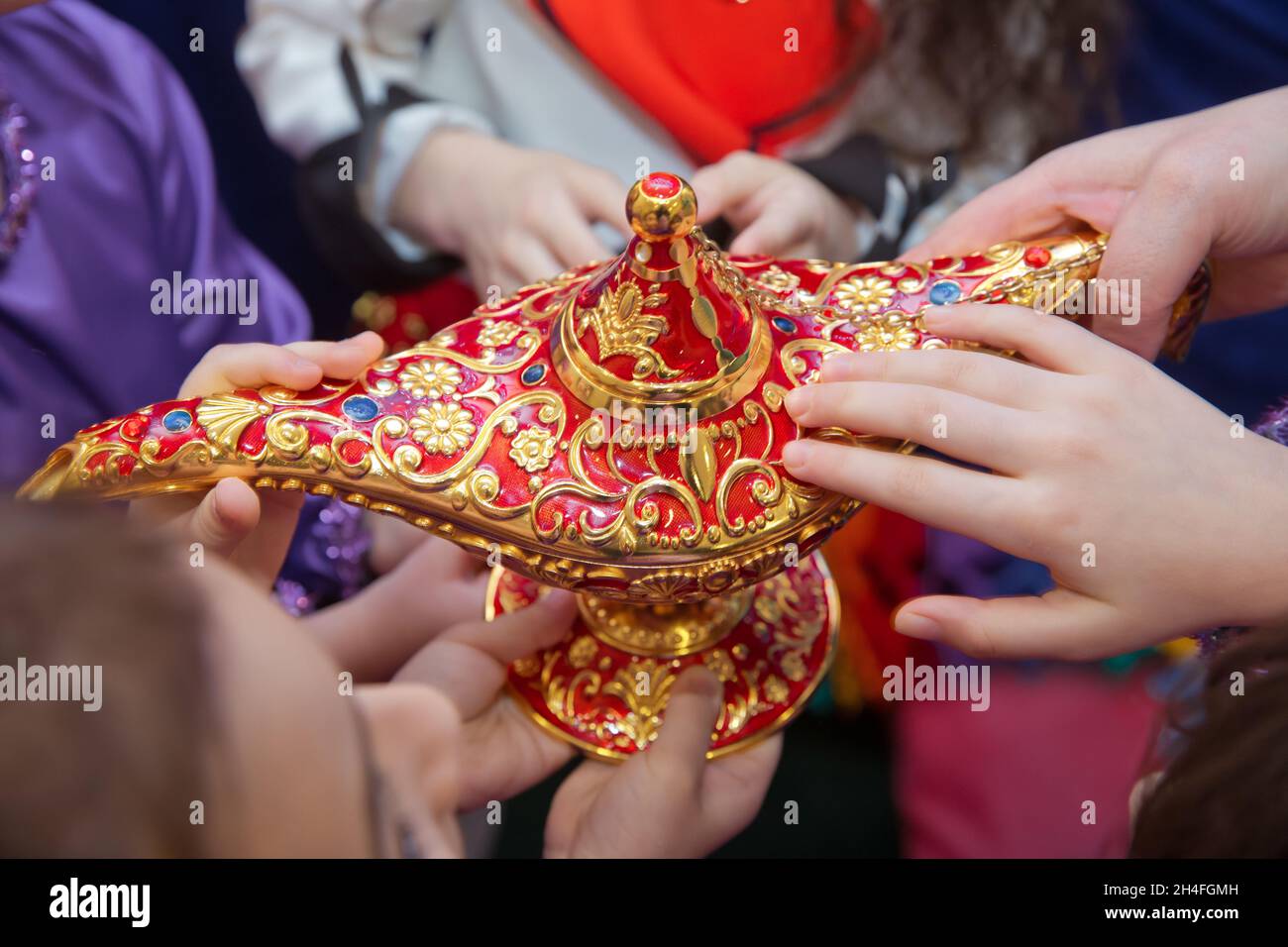 Golden Red Old magic lamp . They touch the old magic lamp with their ...