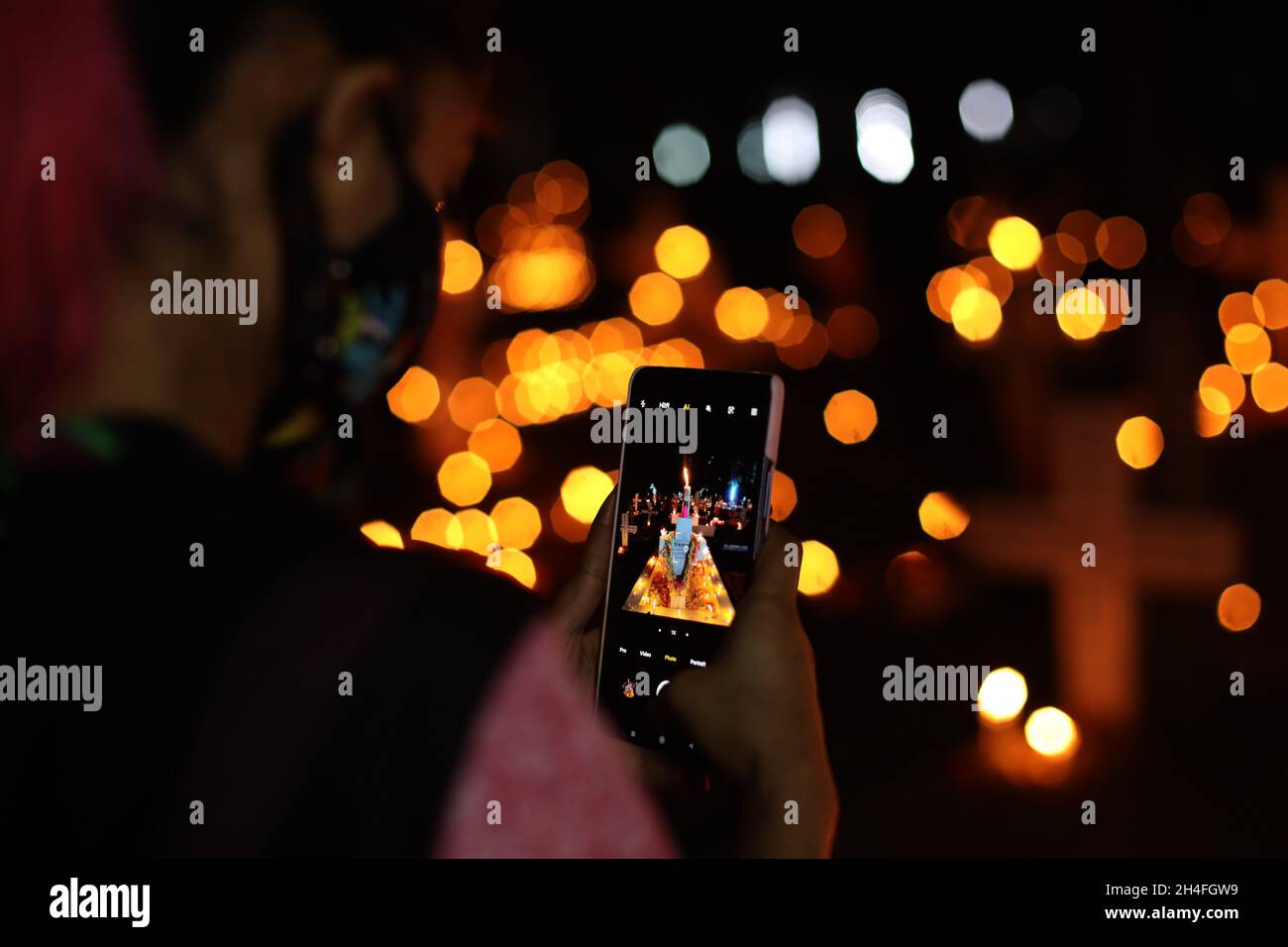 Dhaka, Bangladesh. 02nd Nov, 2021. A catholic family member takes picture of the candle lights ...