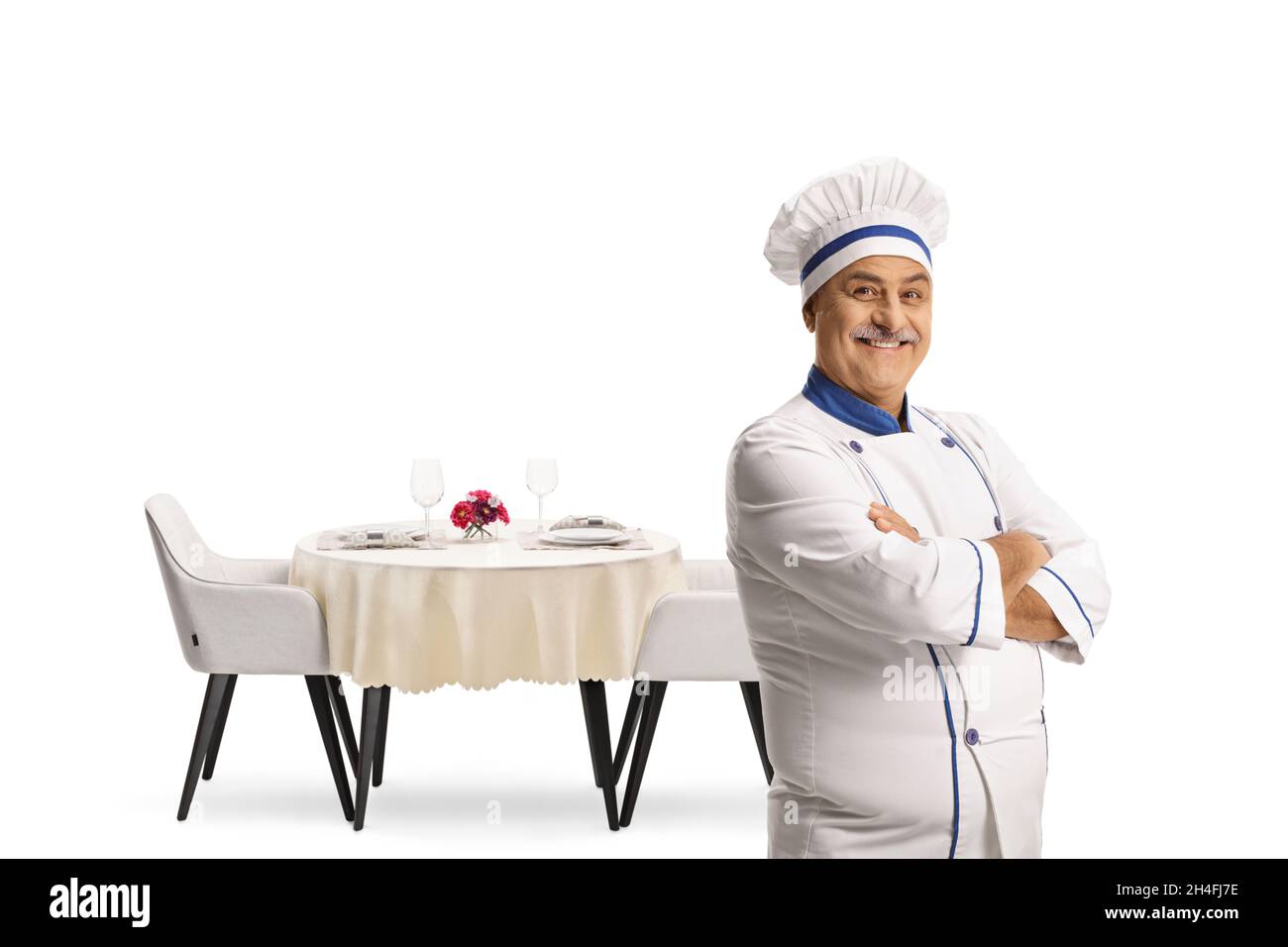Male chef posing in front of a restaurant table isolated on white ...