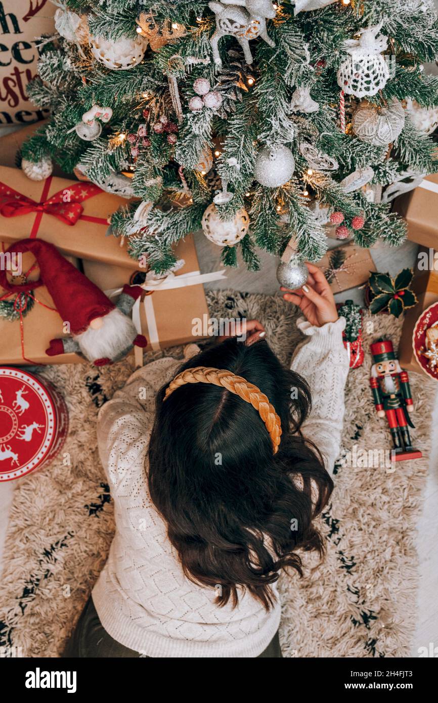 Overhead top view of woman with dark hair laying in front of decorated ...