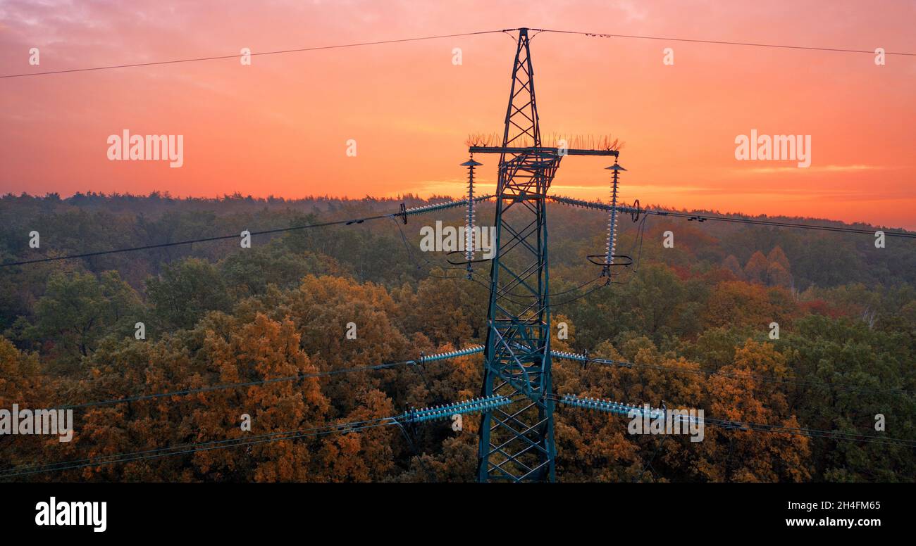 Power line pylon, on a background of sunset and forest Stock Photo - Alamy