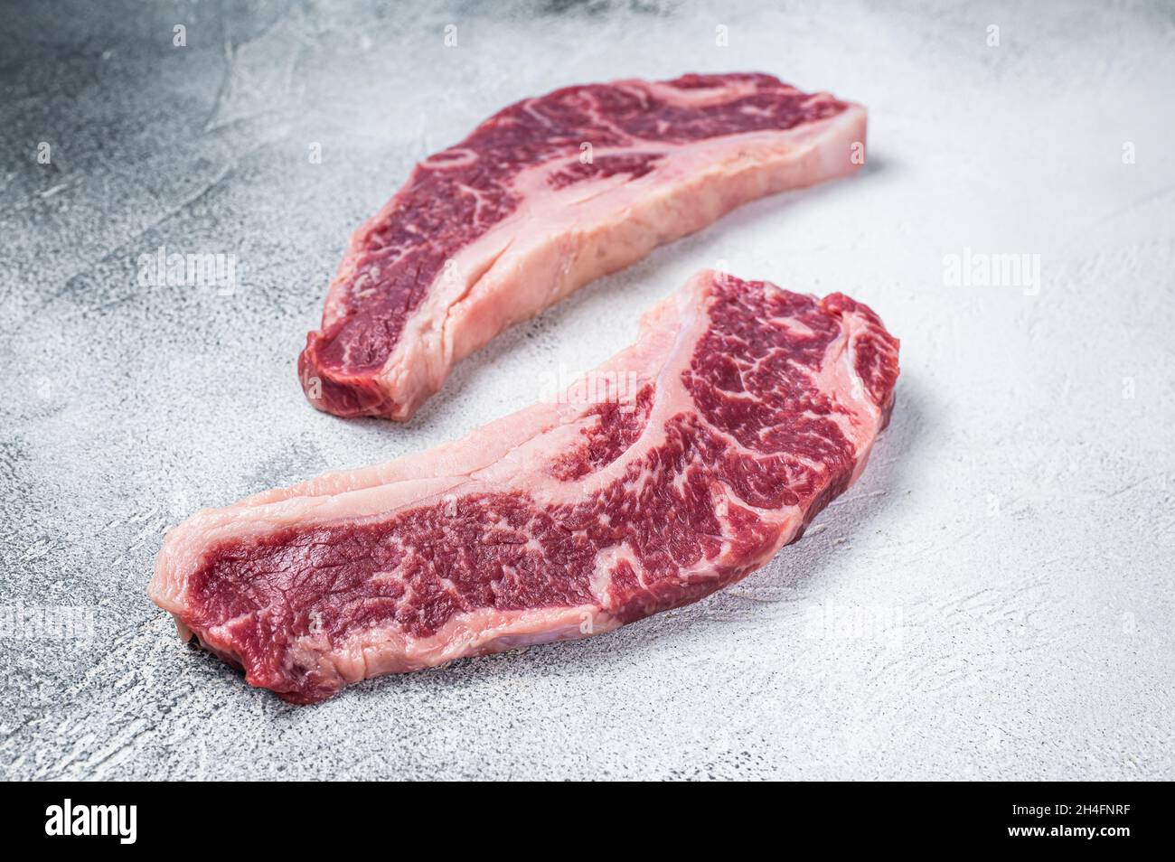 Striploin steak or New York steak, raw beef butchery meat cut. White ...