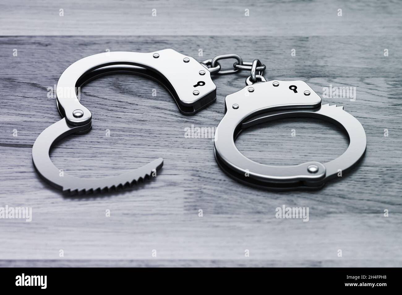 Police metal handcuffs on wooden background Stock Photo - Alamy