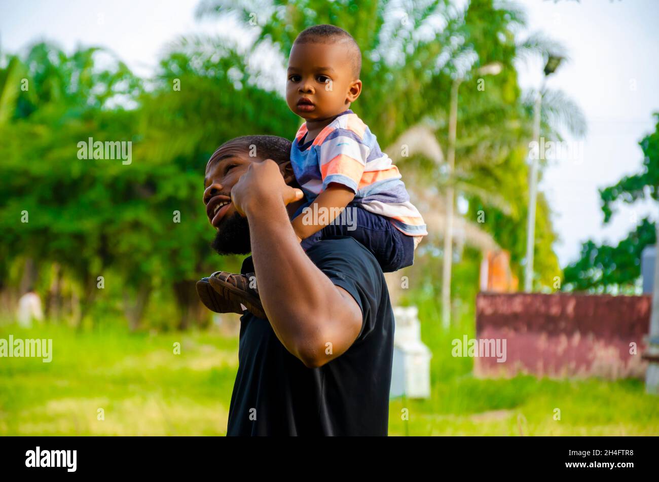 happy little boy stretching out hands while his father carrying him on ...