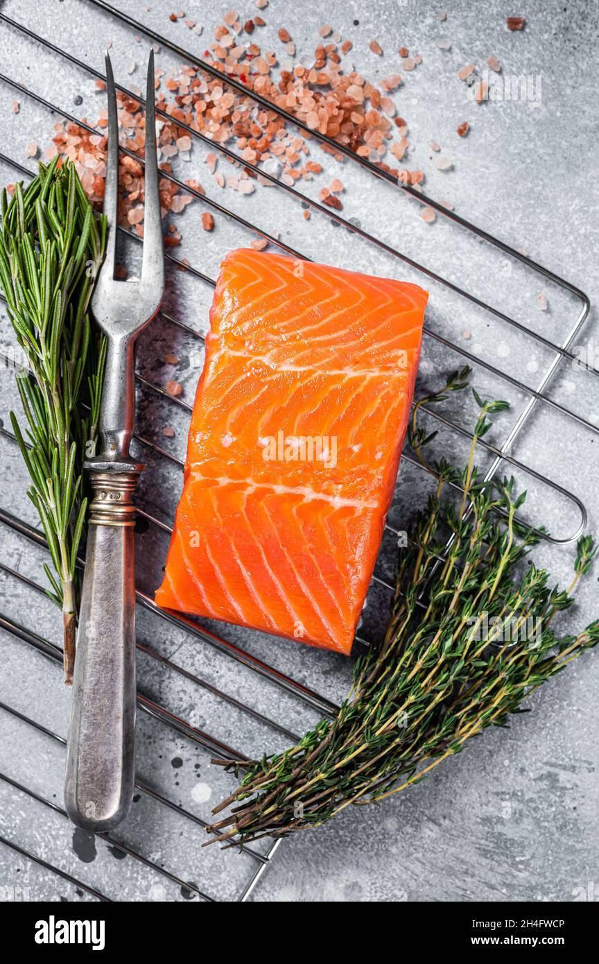 Cooking Raw salmon fillet steak on grill with herbs. Gray background ...