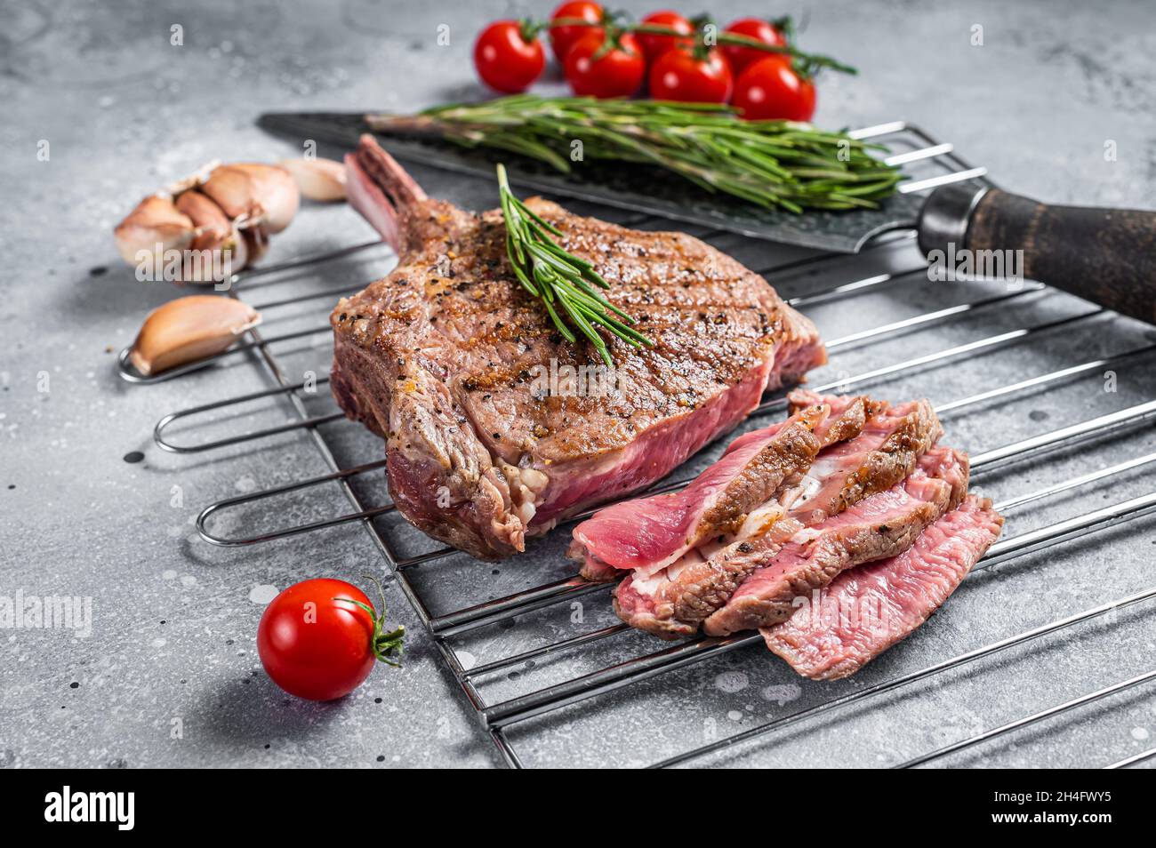 BBQ roasted sliced rib eye Tomahawk beef steak on grill. Gray ...