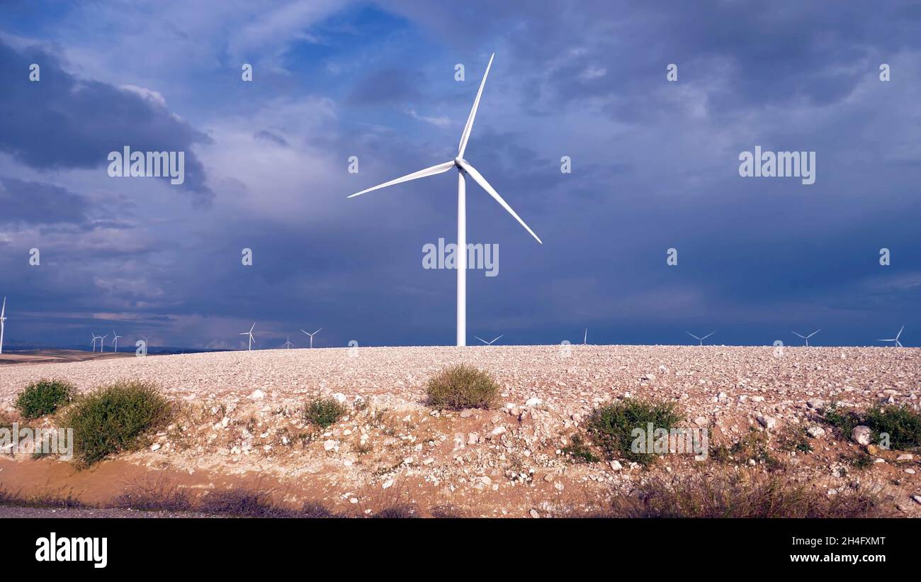 ground view of a wind turbine in the middle of a wind farm with many ...