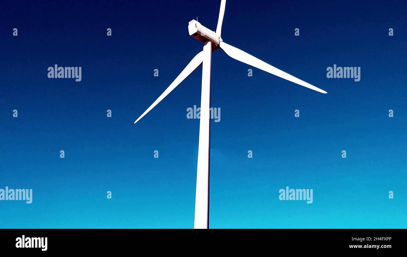view from the ground and from behind of a wind turbine with its blades ...