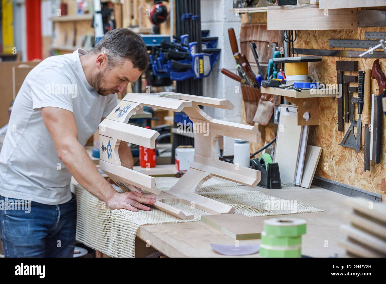 Man working as a carpenter making furniture in a woodwork work shop ...