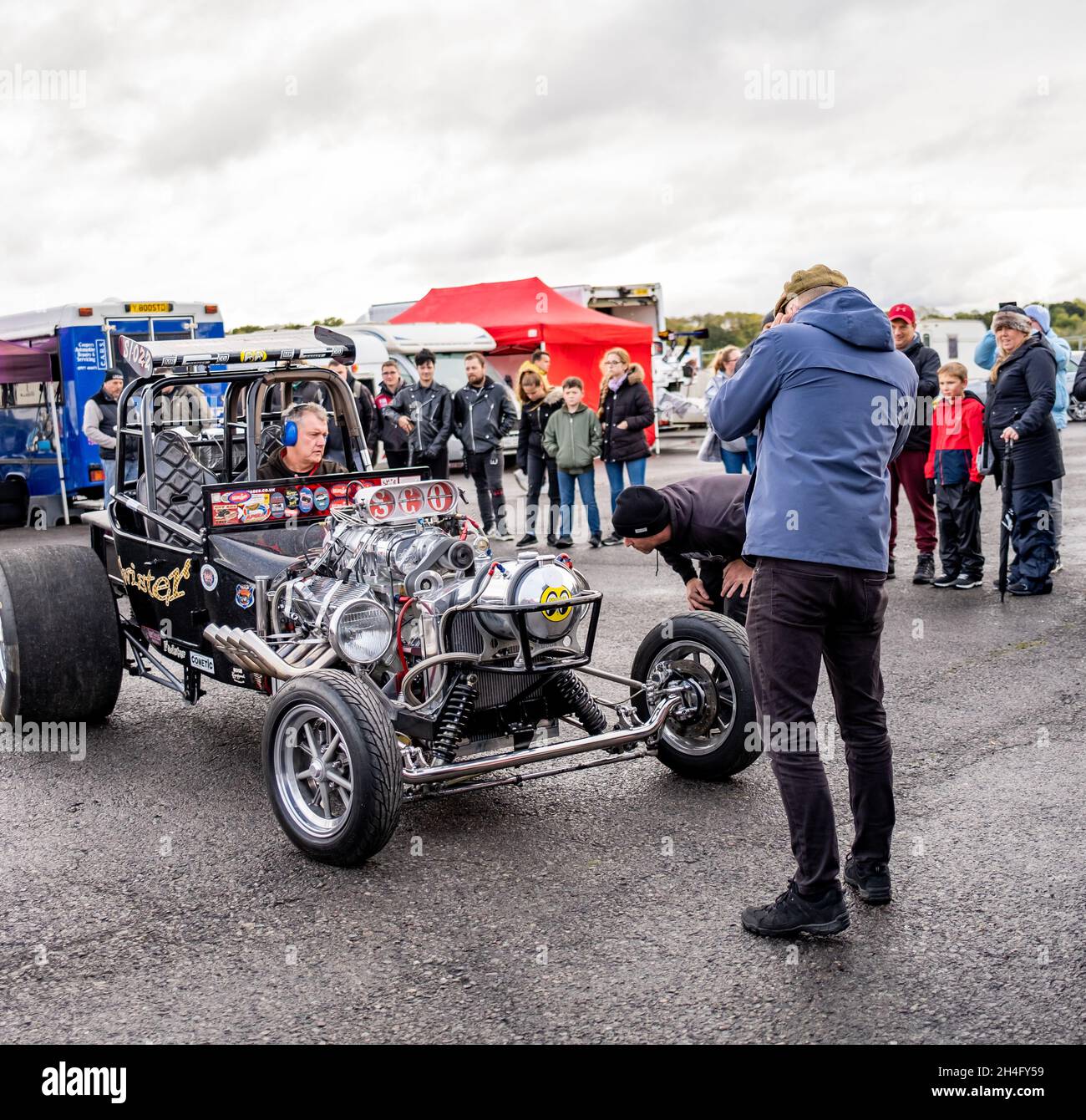 Race goers and spectators gathered around the Twister drag racing car ...