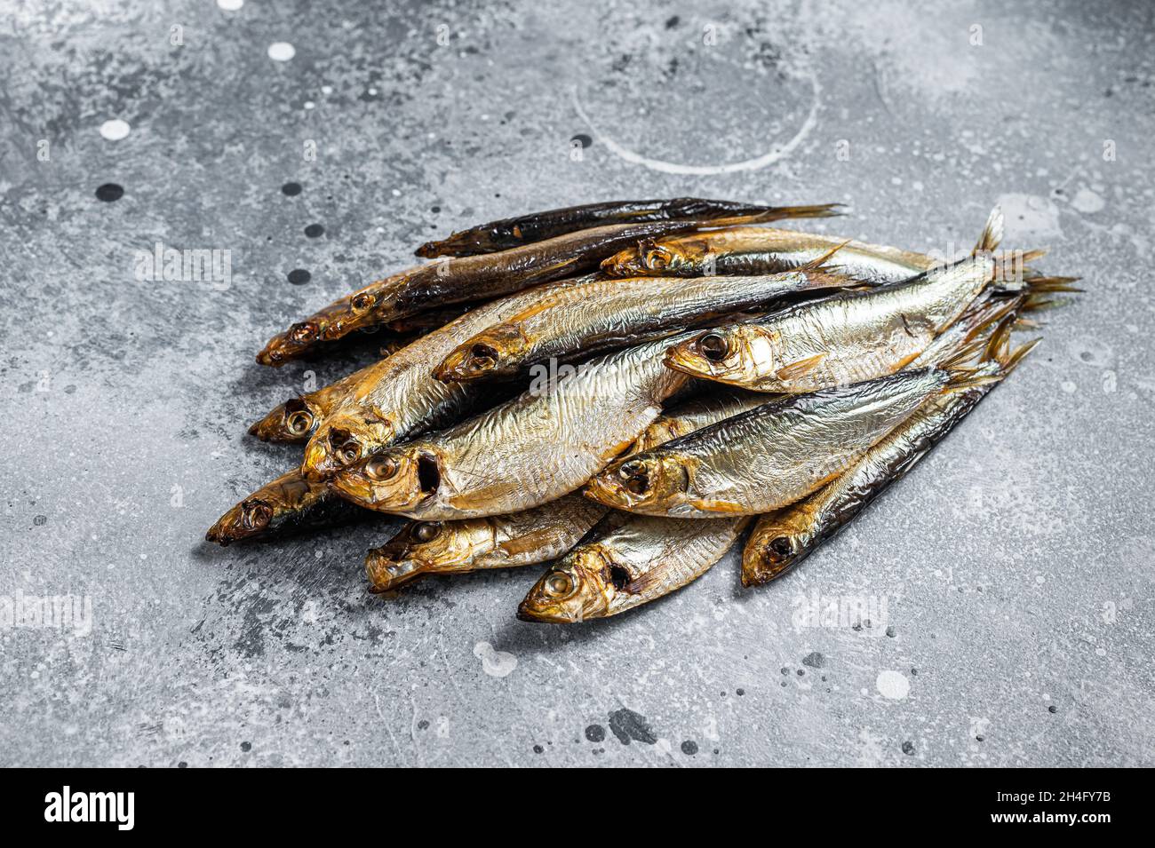 Smoked sprat fishes marinated with spices. Gray background. Top view ...