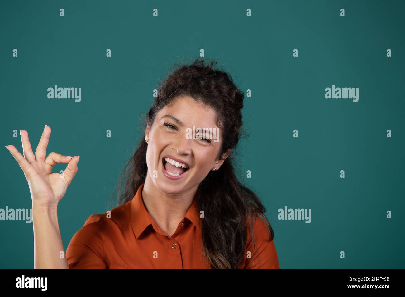 Pretty young woman showing ok sign with fingers, hand gesture, on black ...