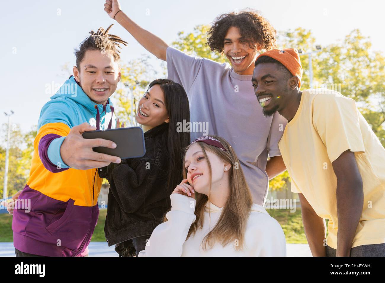 Multicultural group of young friends bonding outdoors and having fun ...