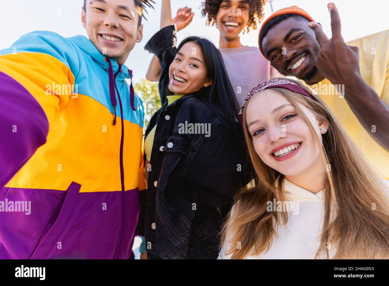 Multicultural group of young friends bonding outdoors and having fun ...