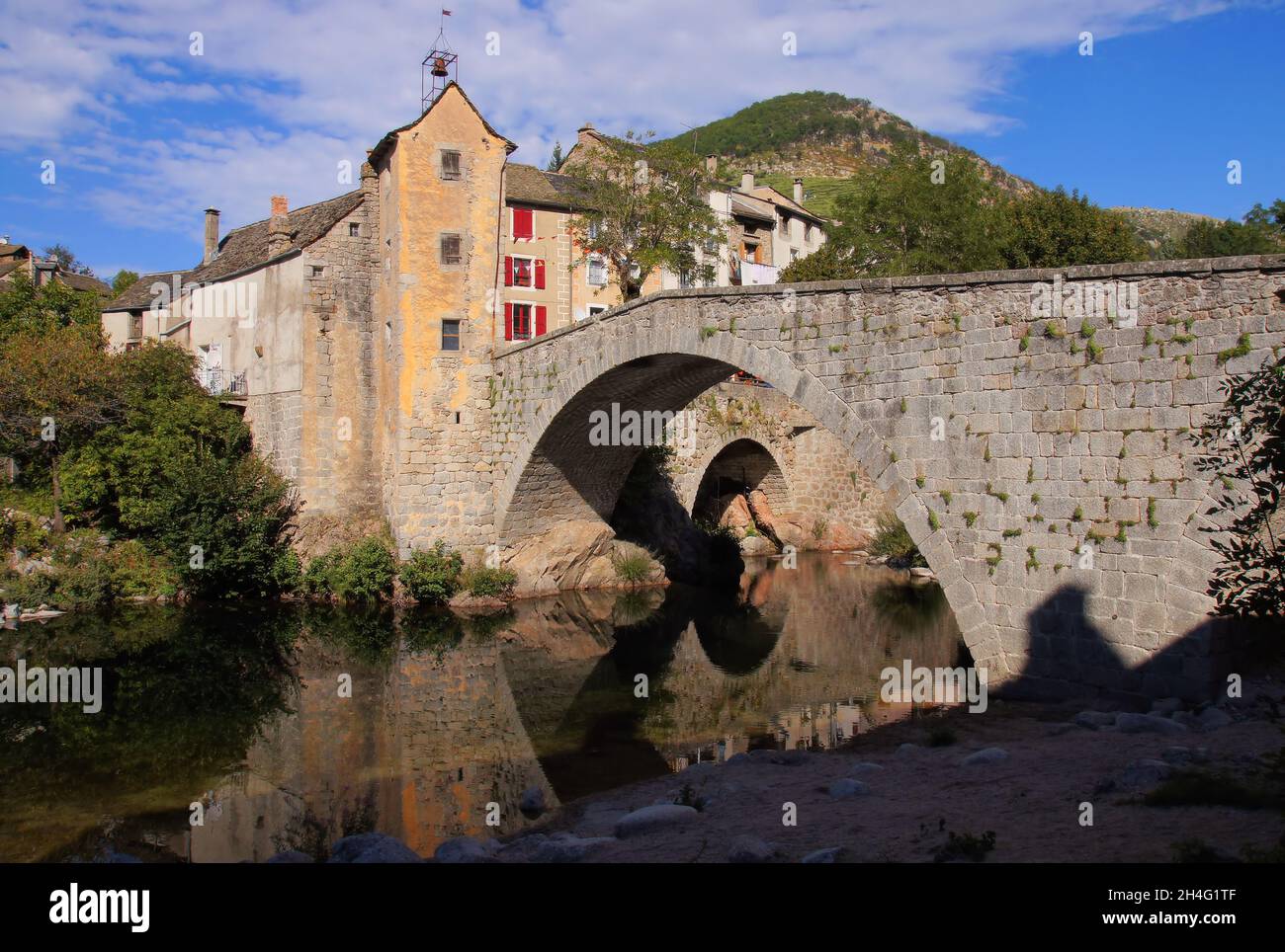 Old bridge with reflections in the River Tarn at Le Pont de Montvert in ...