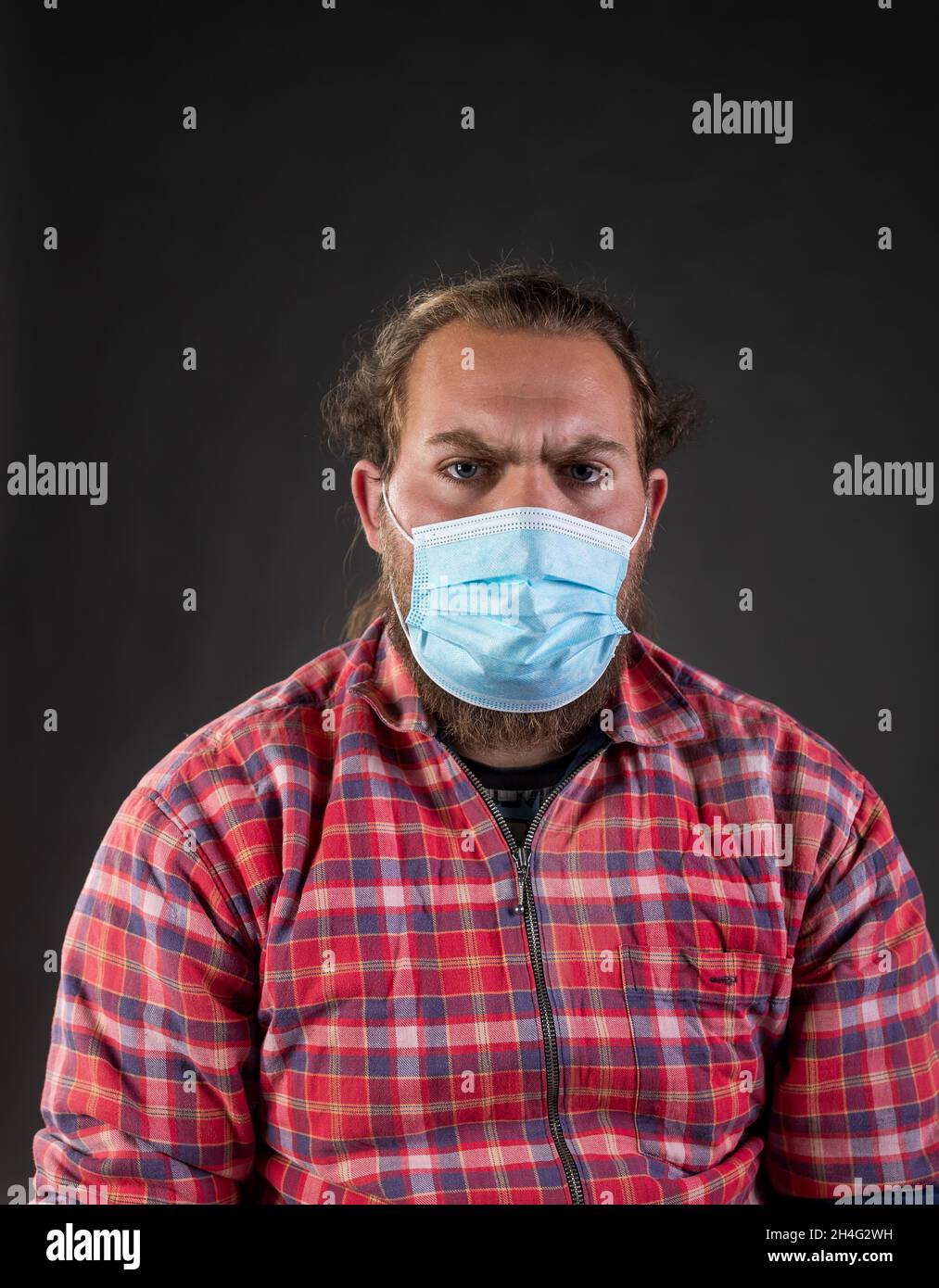 Portrait of angry man wearing facial mask as virus protection concept ...
