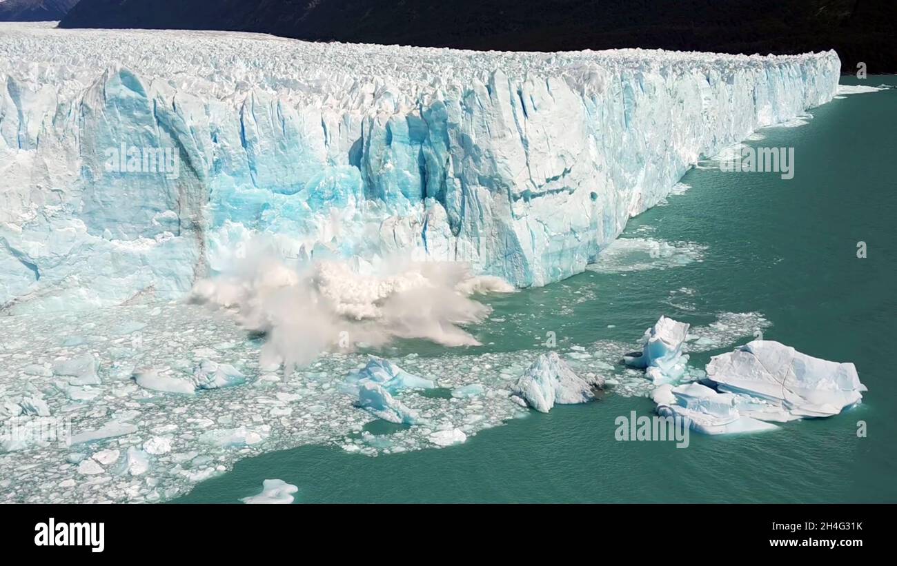 drone view of a large chunk of glacier ice breaking off due to melting ...