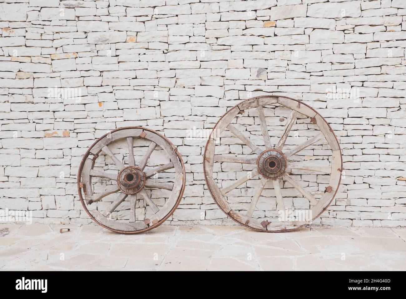 Two vintage wooden wheels. Antique masonry in beige shades. Beautiful ...