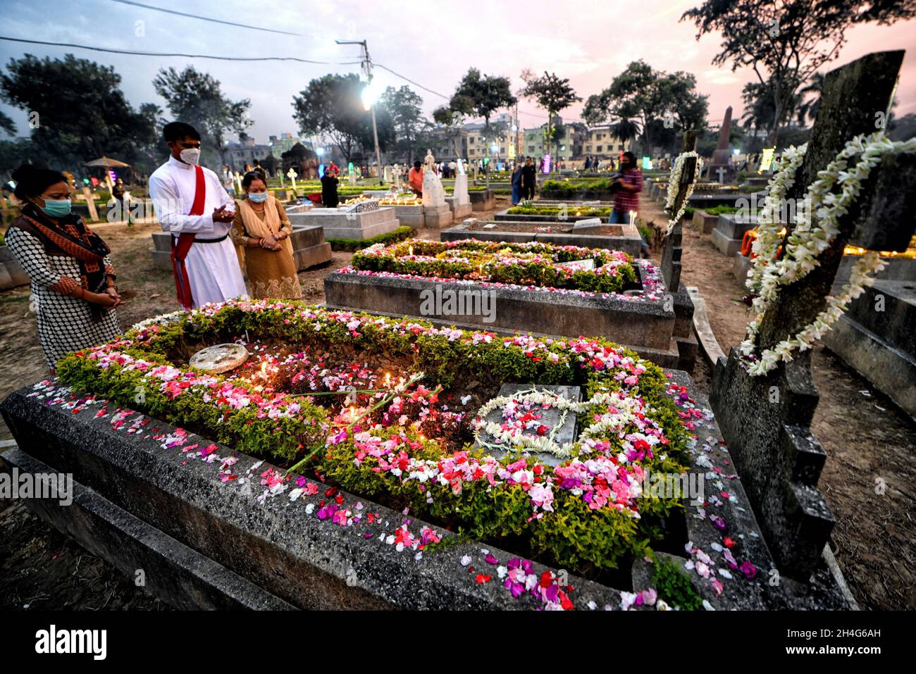 Christian family members pay respect and offer prays beside the grave ...