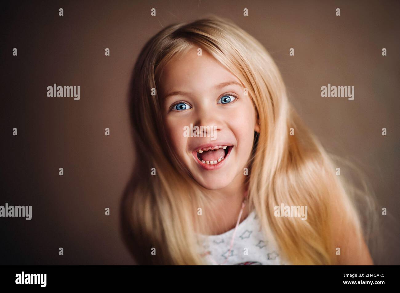 Charming child in the crib. Charming baby in yellow holds the handrails ...