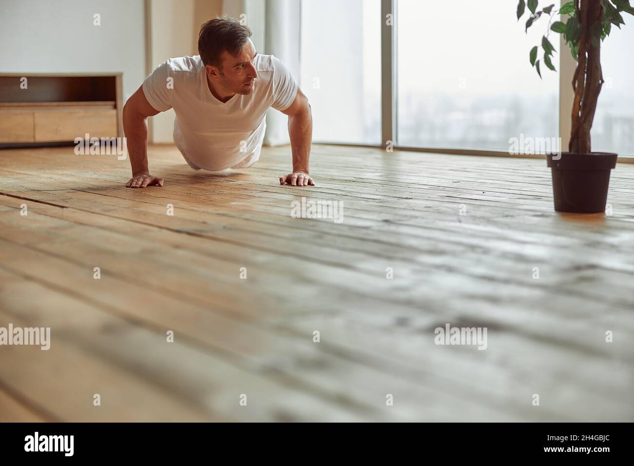 Strong man doing plank at home alone Stock Photo - Alamy