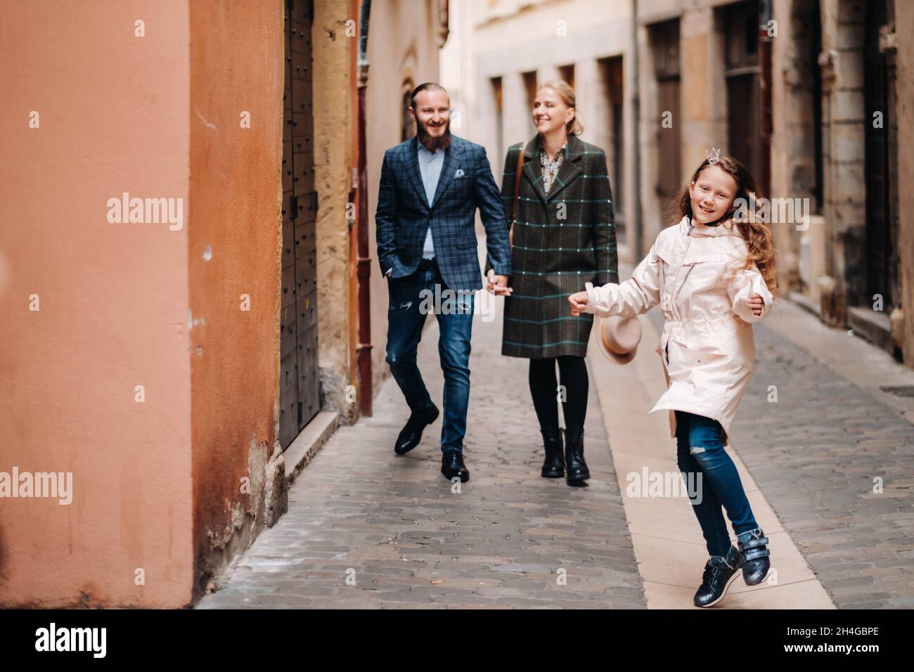 A beautiful family with strolls through the old city of Lyon in France ...