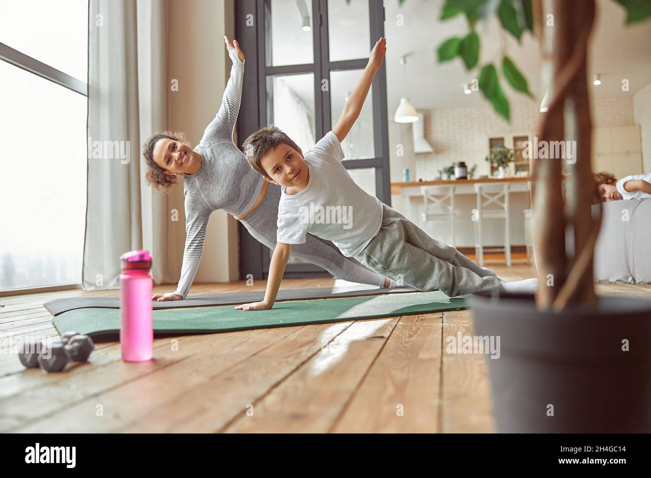 Active mother doing workout with son at home Stock Photo - Alamy