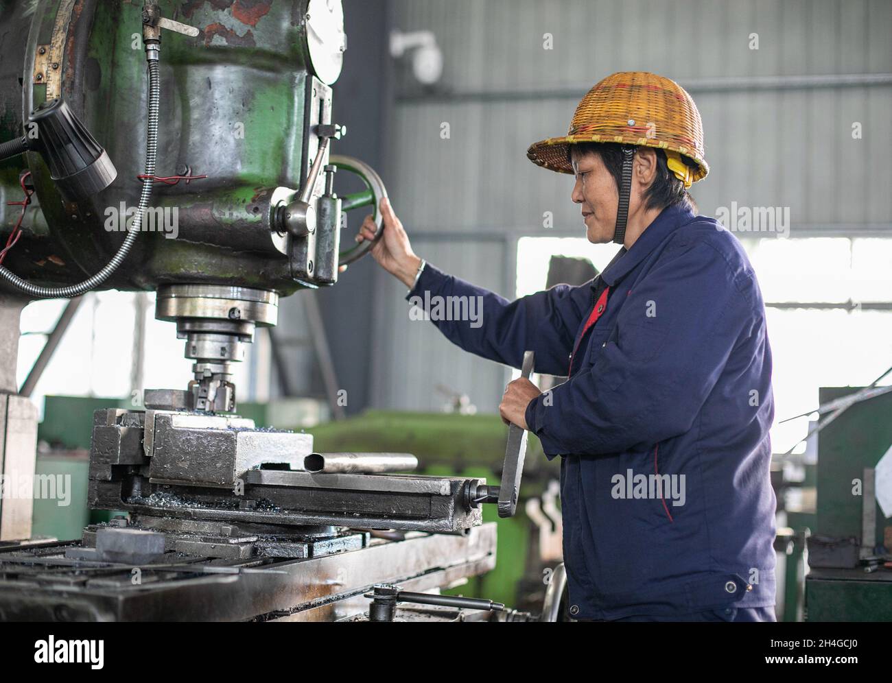 A worker works on machinery and equipment orders at a workshop of a ...