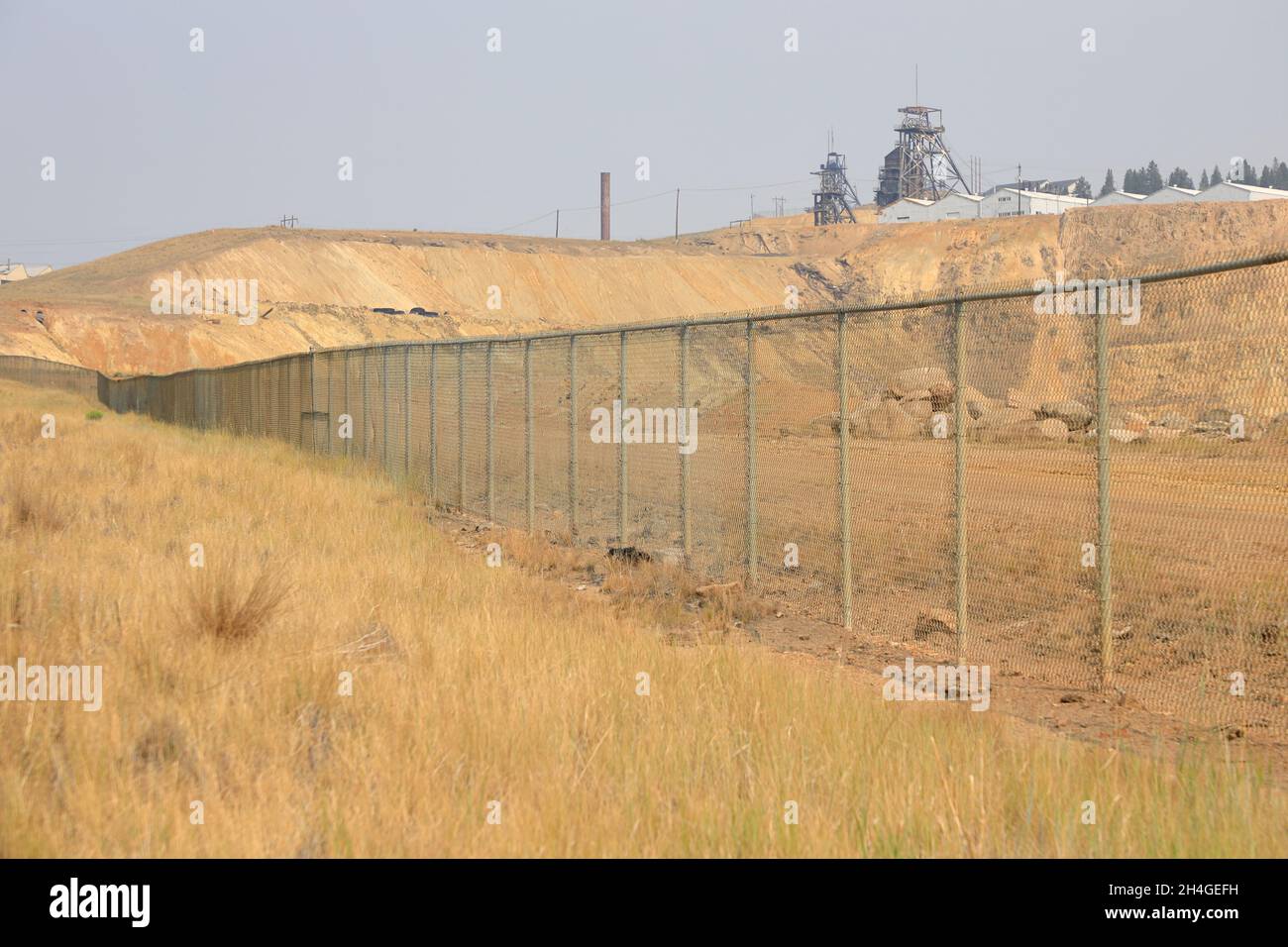 Fenced up area of a copper mine with headframes in background.Butte ...