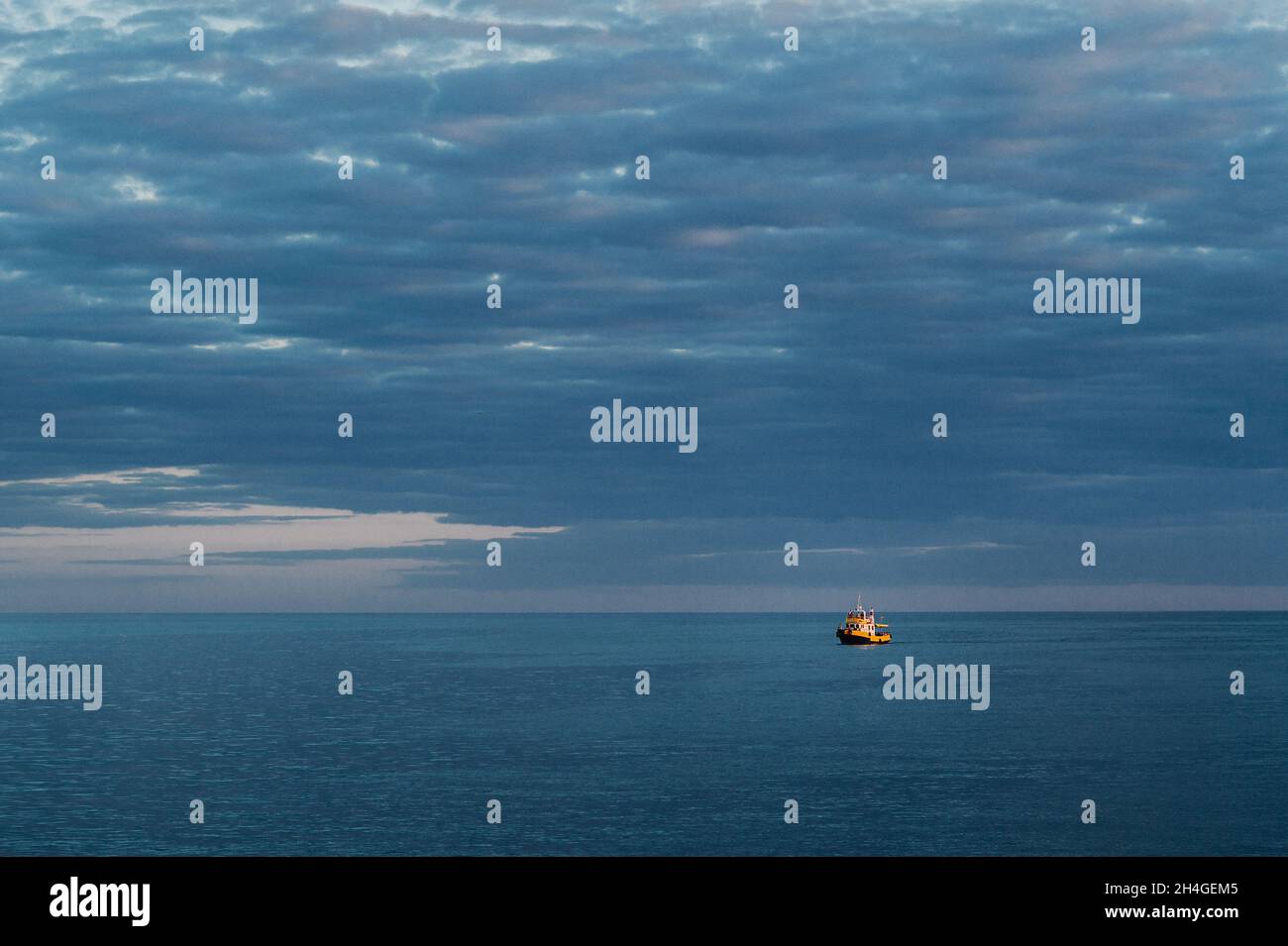 Small boat against tropical sunset hi-res stock photography and images ...