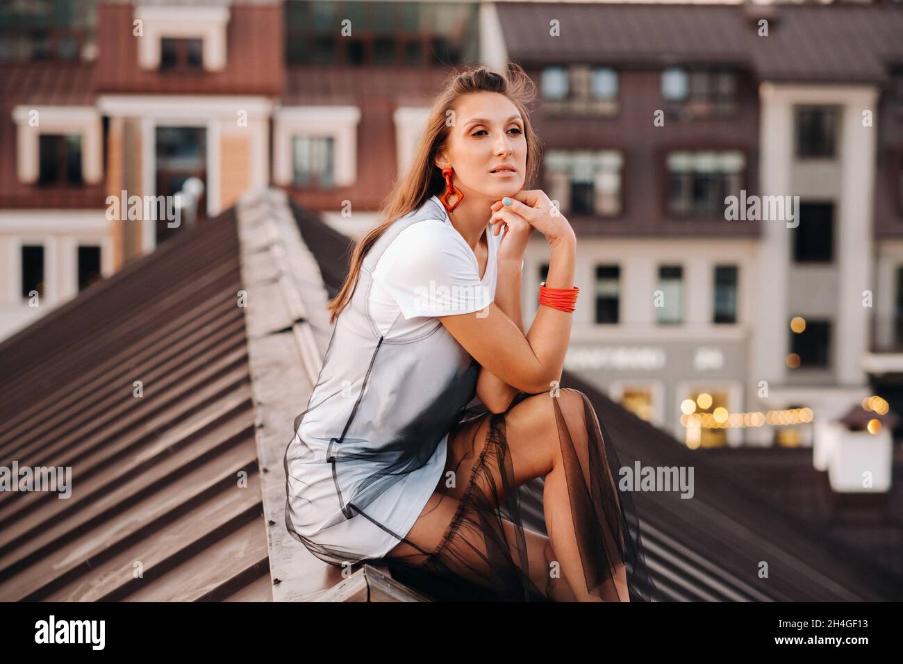 Girl sitting on roof sunset hi-res stock photography and images - Alamy