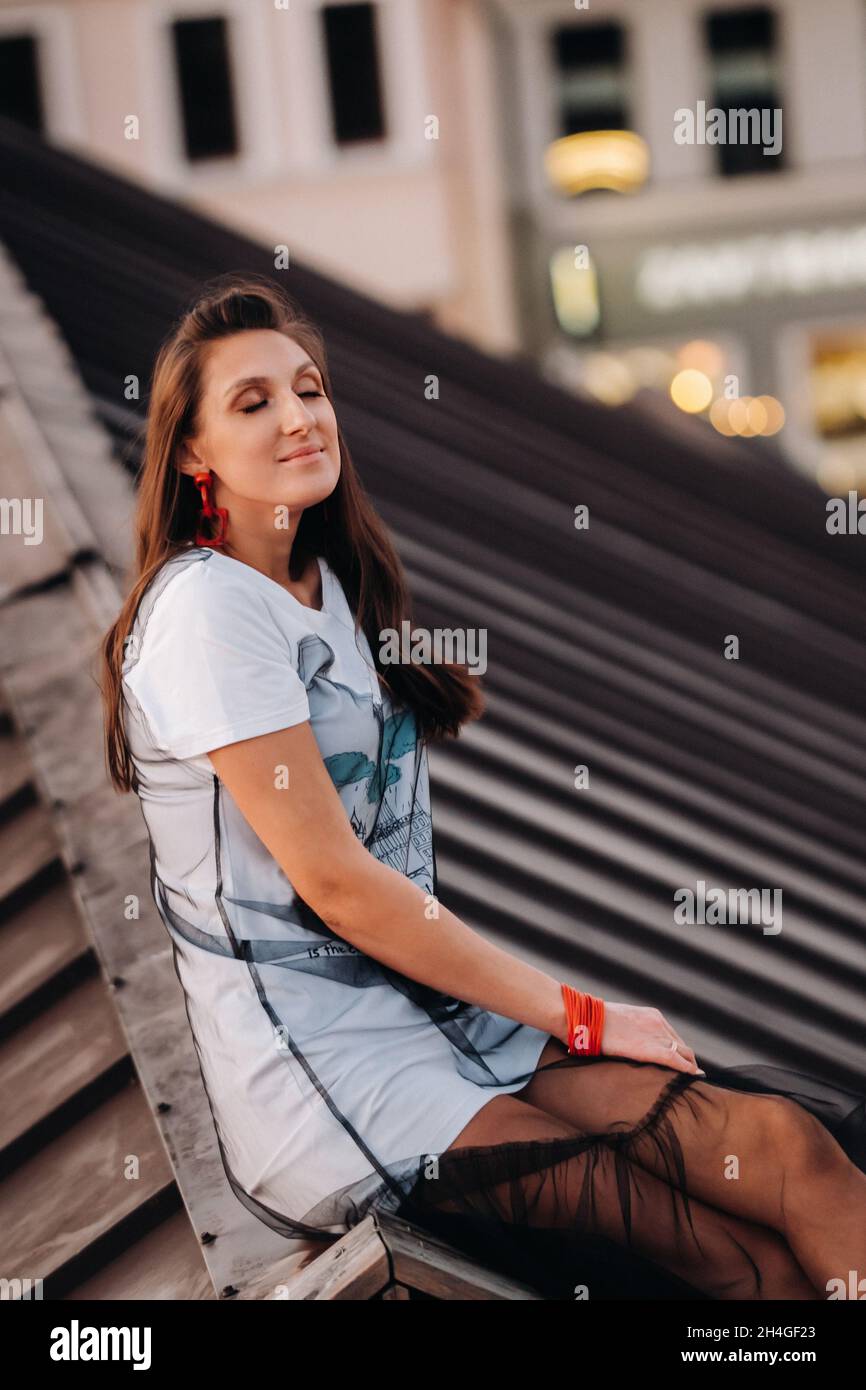 Girl sitting on roof sunset hi-res stock photography and images - Alamy