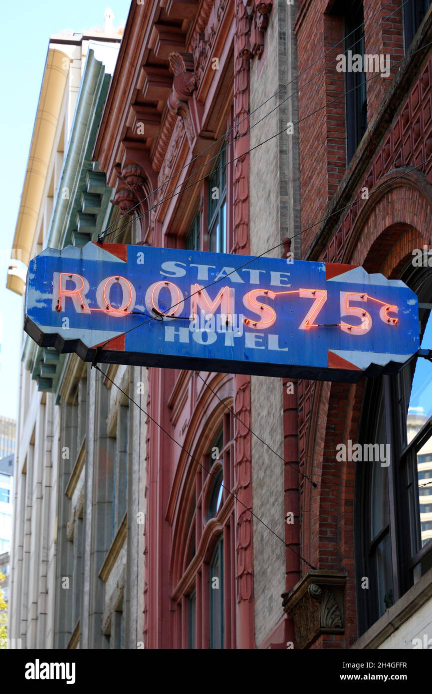 Overhanging neon sign of State Hotel Rooms 75 c on the wall of historic ...